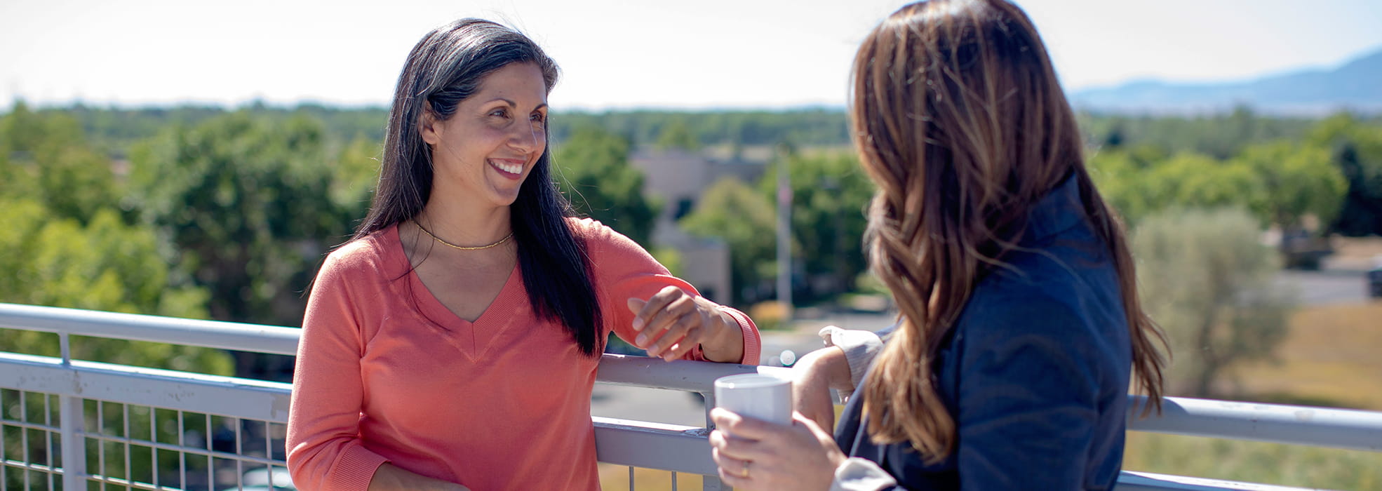 two women talking on a balcony