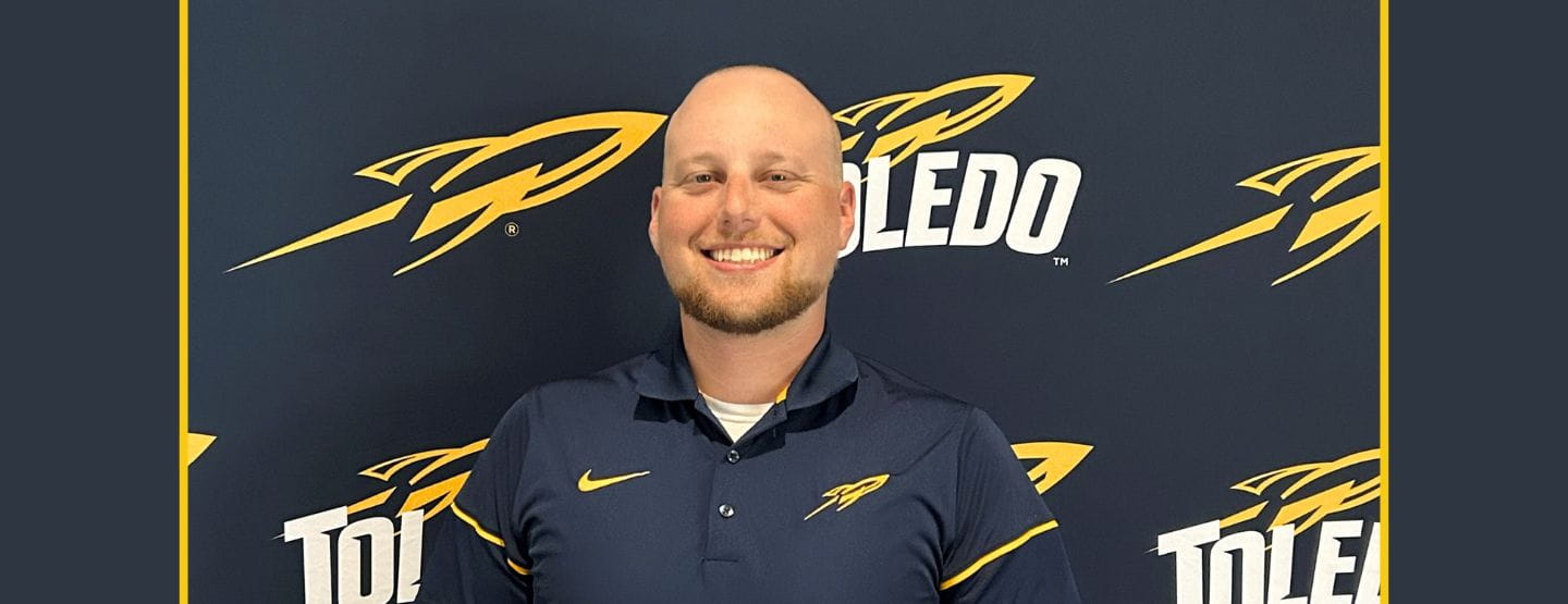 Tyler Fisher smiling in front of a University of Toledo backdrop.