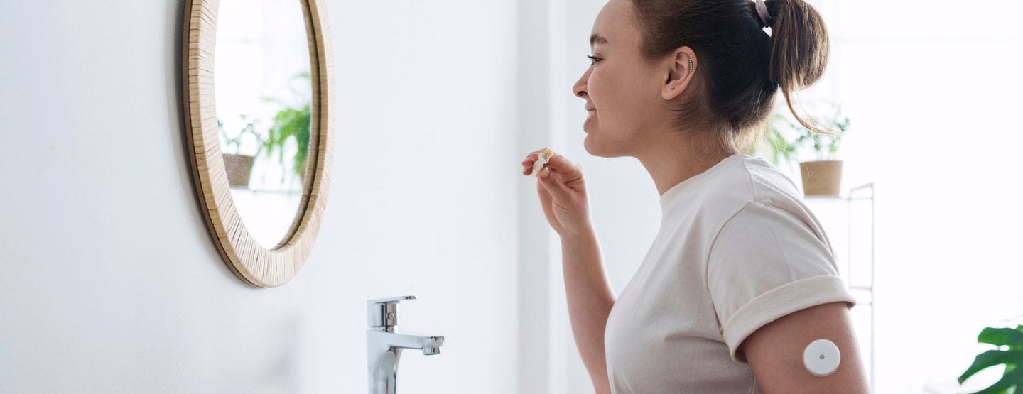 Woman with diabetes brushing teeth in bathroom at home